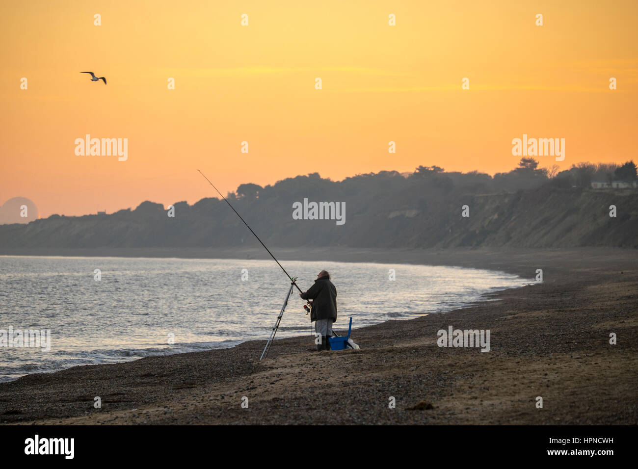 Sea angler, fishing, Dunwich beach, Suffolk UK, at dusk Stock Photo - Alamy