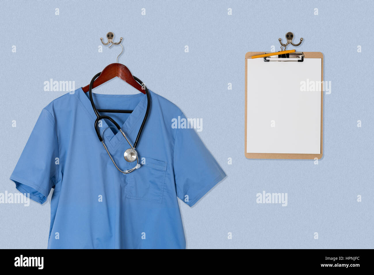 Blue medical scrubs uniform shirt hanging on a hanger with stethoscope ...
