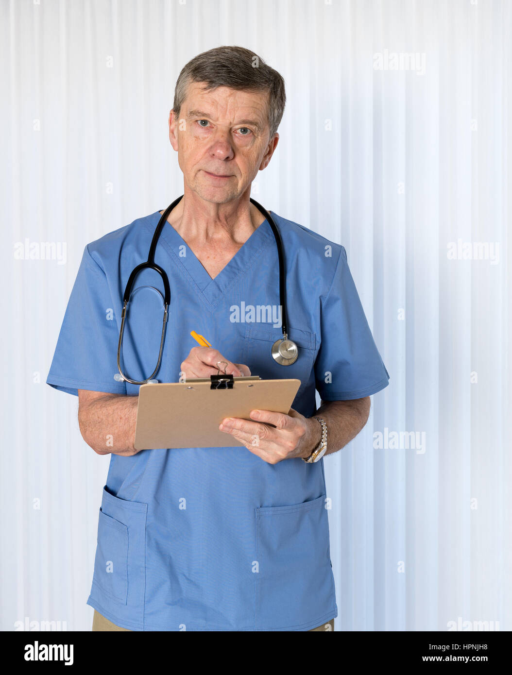 Senior male caucasian doctor with stethoscope in medical scrubs and ...