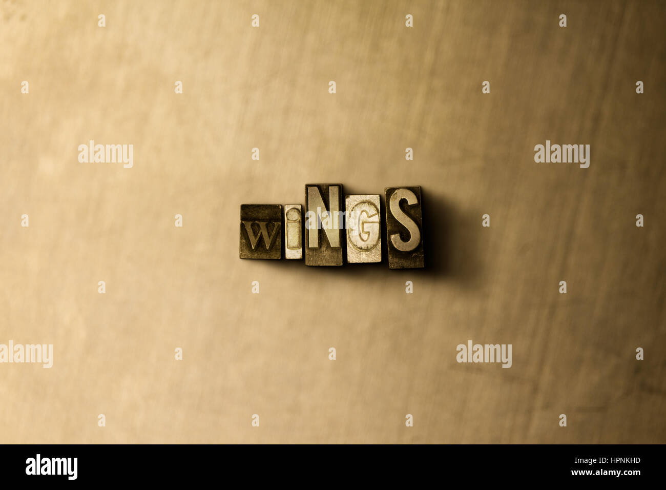 WINGS - close-up of grungy vintage typeset word on metal backdrop ...