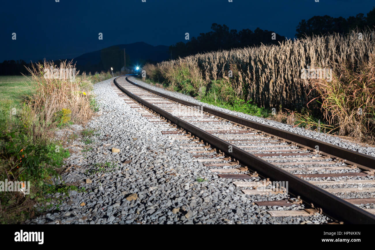 Railroad crossing with Diesel locomotive engine coming towards the ...
