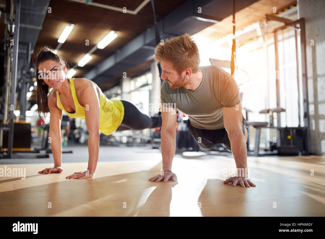 Female and male doing exercises for strengthen hands muscles in gym ...