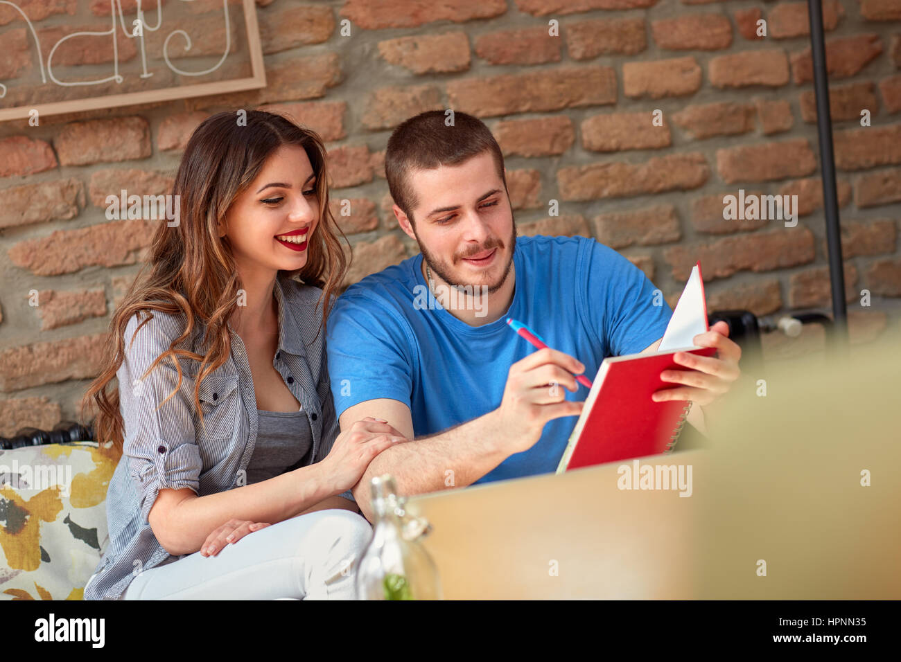 Two students male and female write and learn in cafe Stock Photo - Alamy