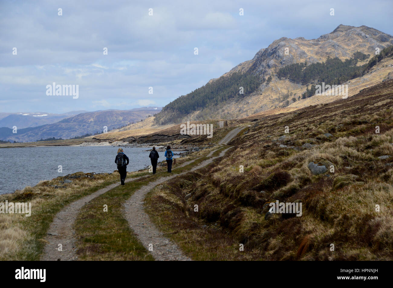 Three Hikers Walking on the side of Lochan na h-Earba on the East ...