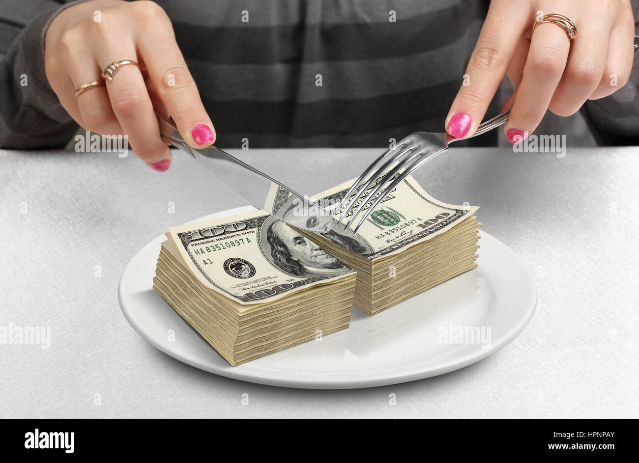 Cut money on plate, cut budget concept Stock Photo - Alamy