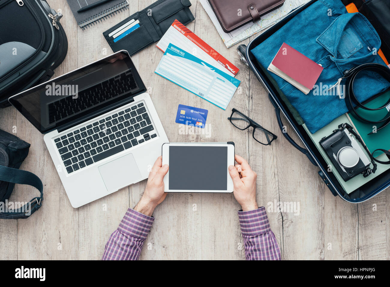 Traveler getting ready for a trip, he is packing his bag and using a ...