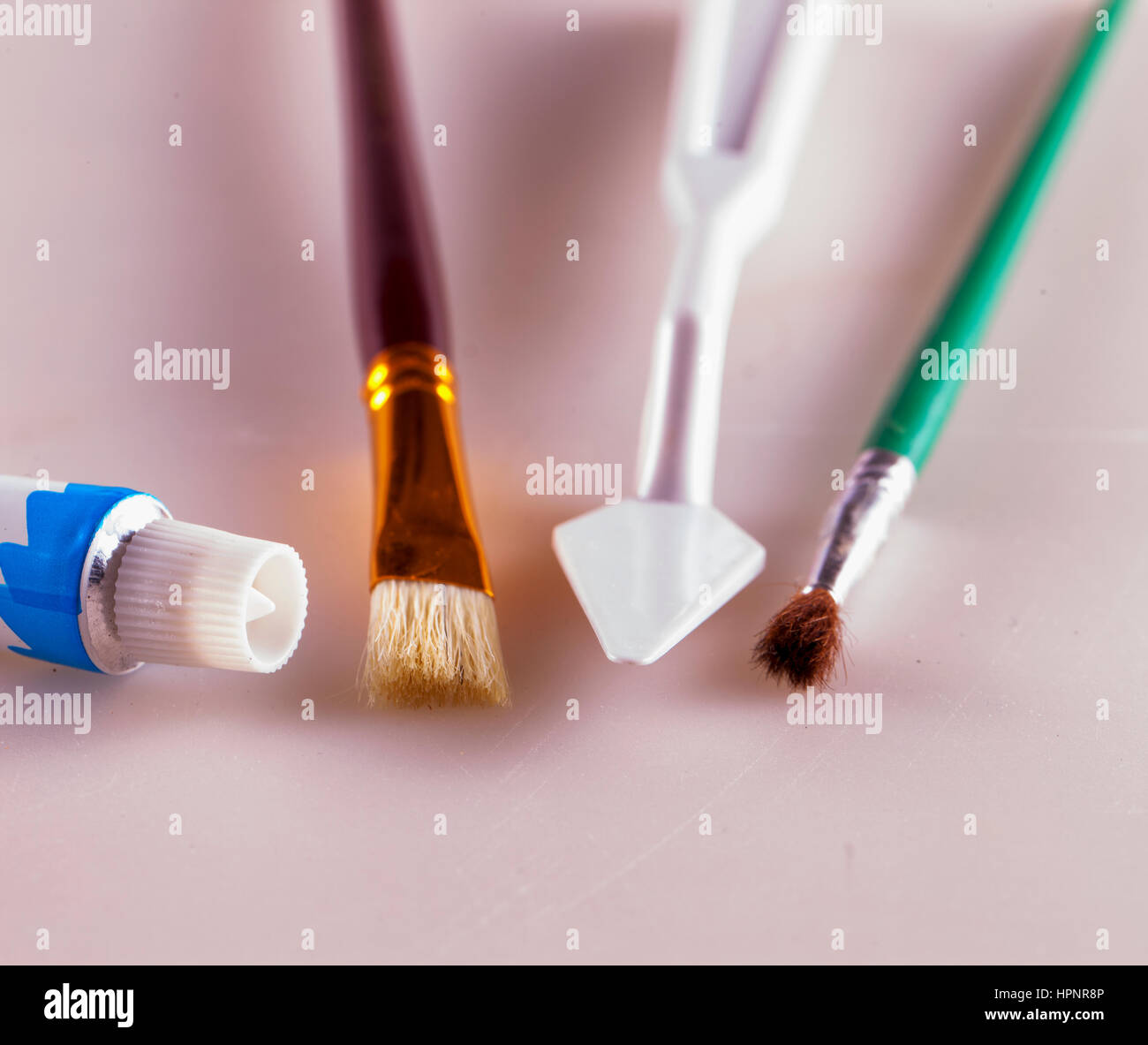 Brushes and paint in close up over white background, horizontal image ...