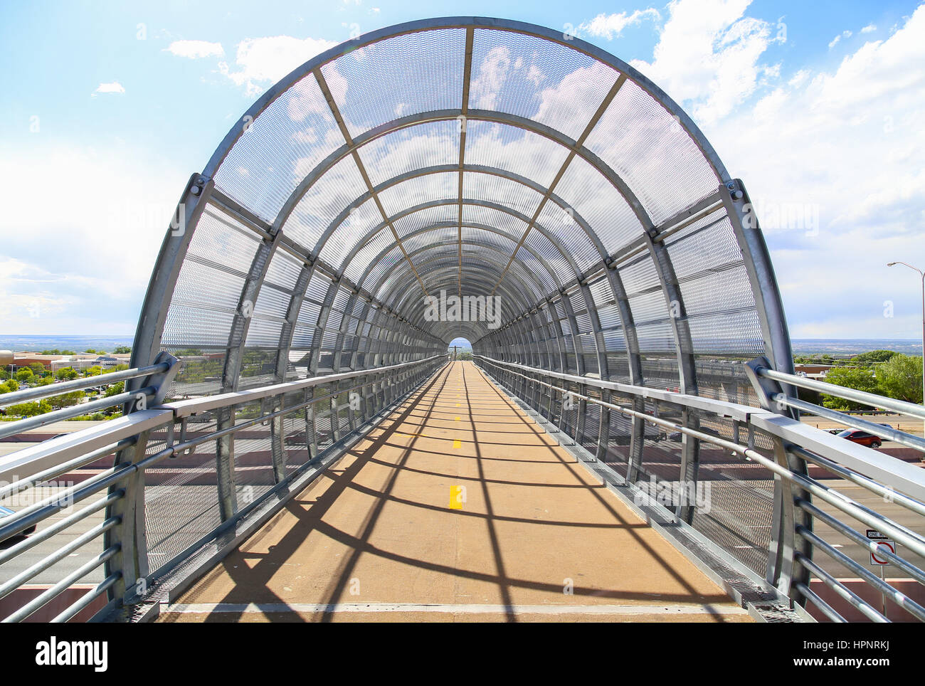 Looking through a transparent tunnel on a pedestrian bridge over the ...