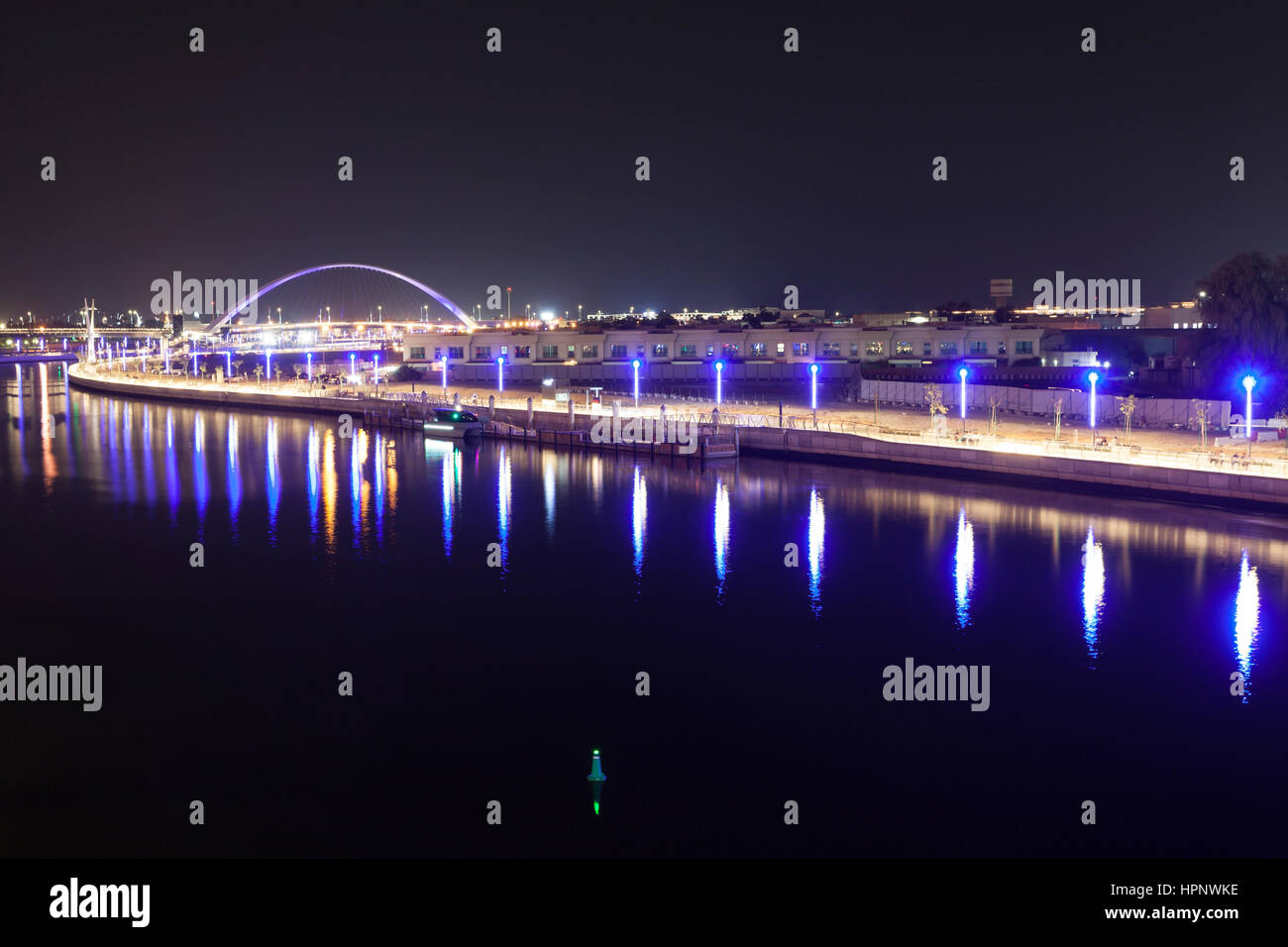 Dubai Water Canal and Arch Bridge illuminated at night. United Arab ...