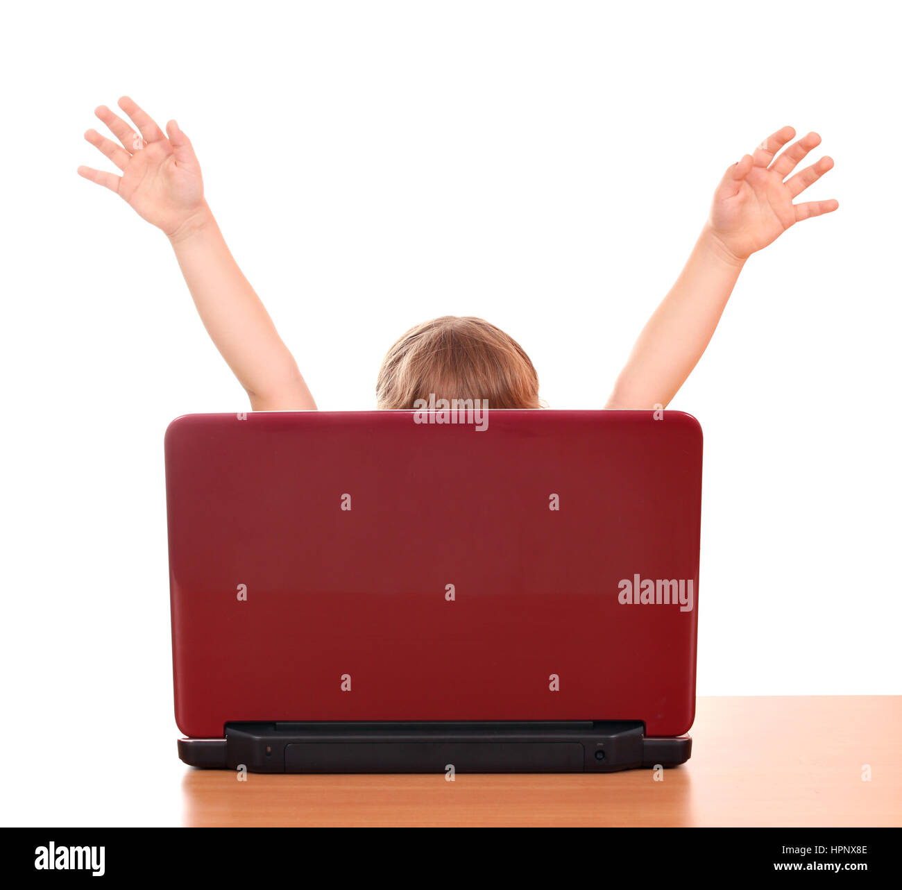 happy little girl raised his hands behind laptop Stock Photo - Alamy