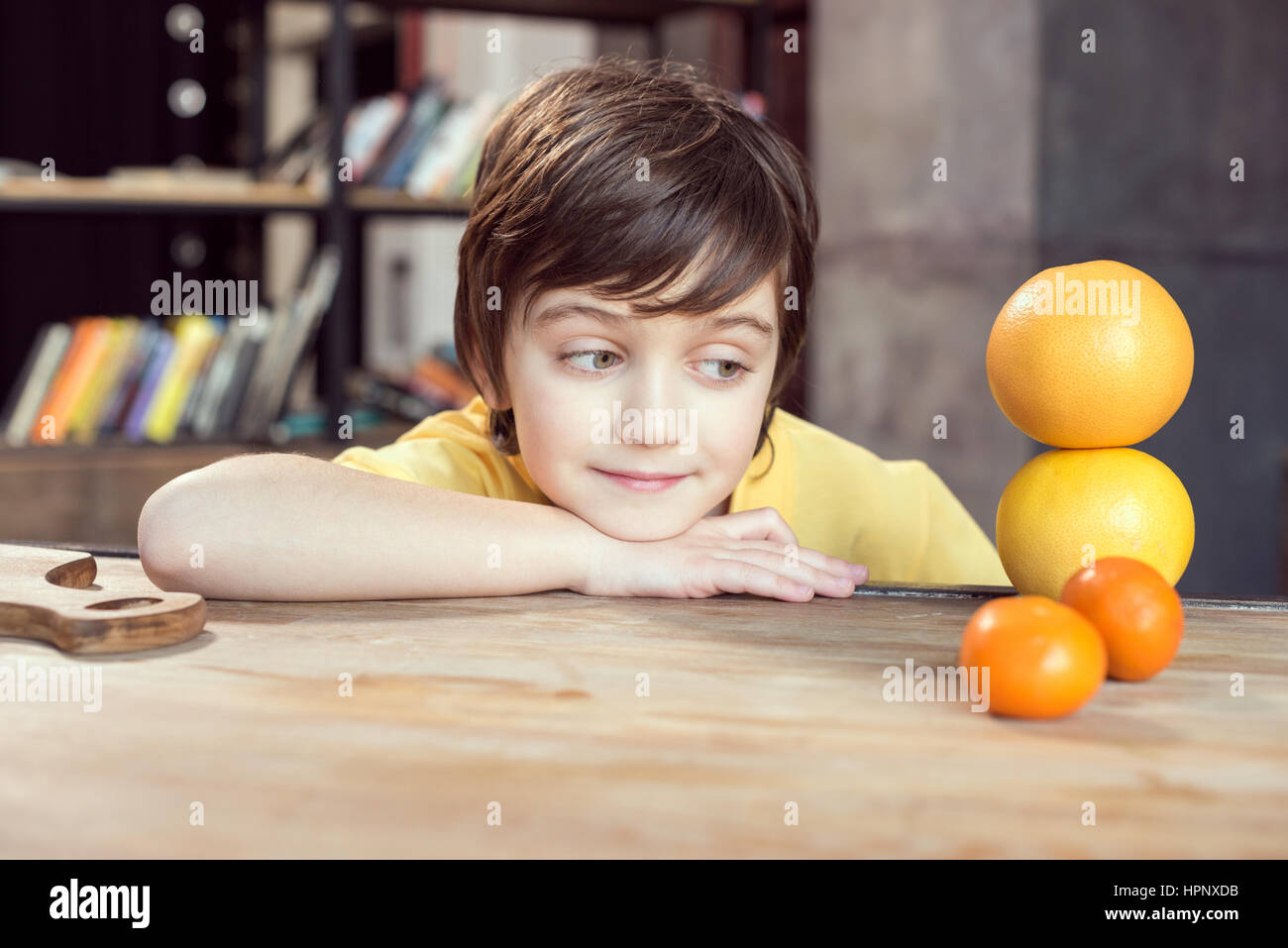 smiling boy leaning at table and looking at fresh fruits Stock Photo ...