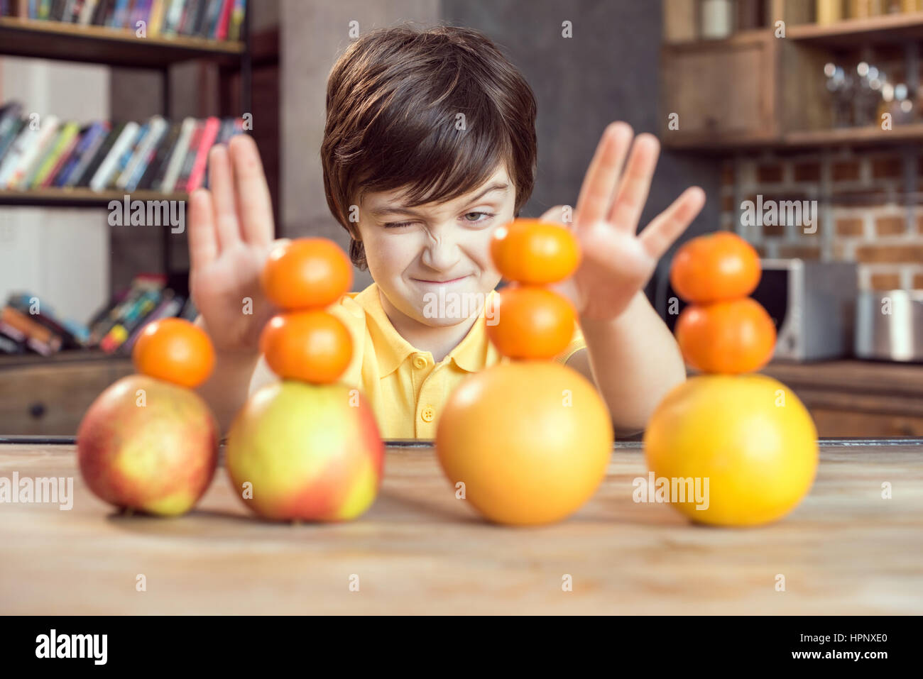 little boy playing with fresh fruits on wooden table Stock Photo - Alamy
