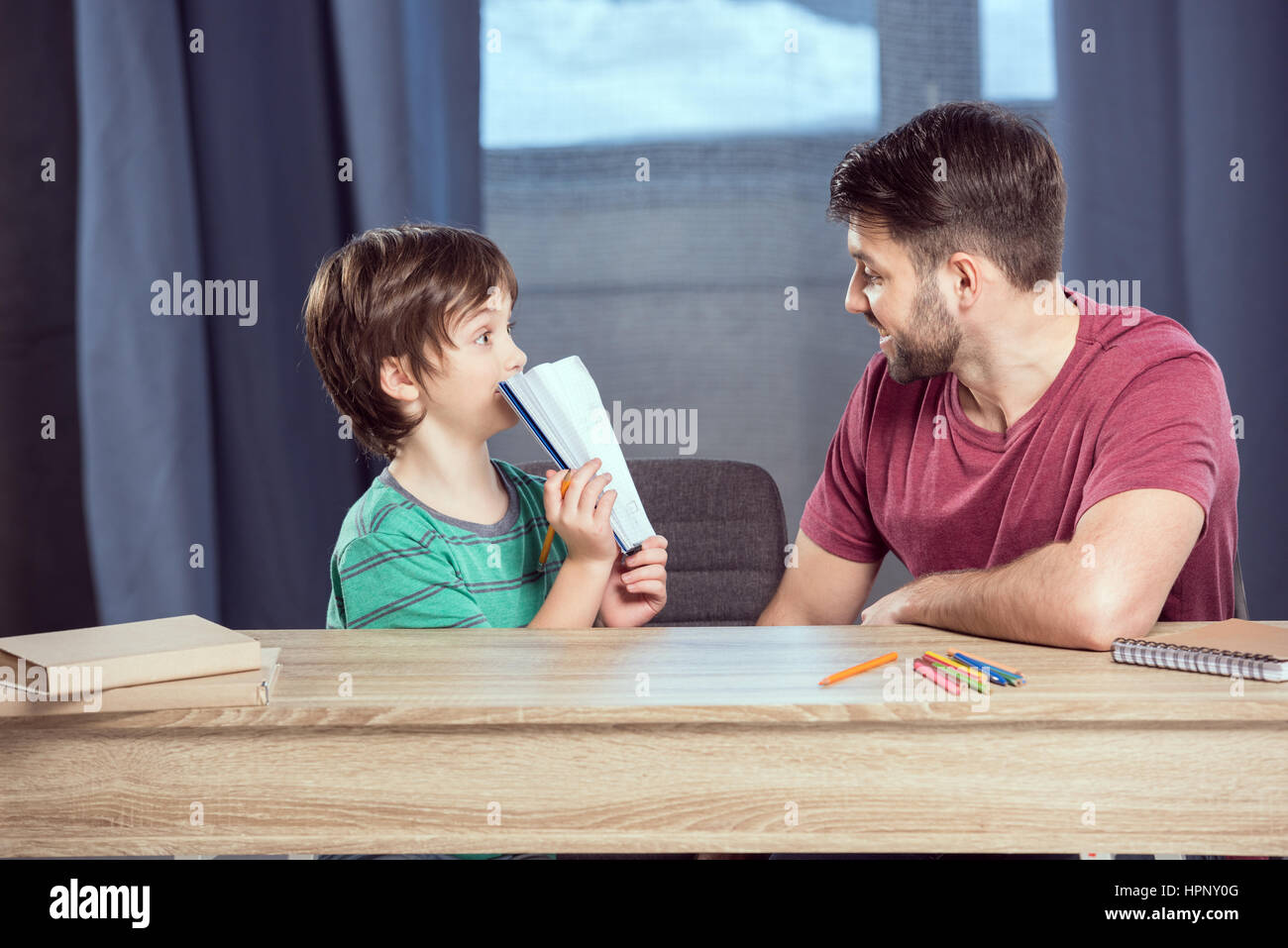 son showing done homework to father Stock Photo - Alamy