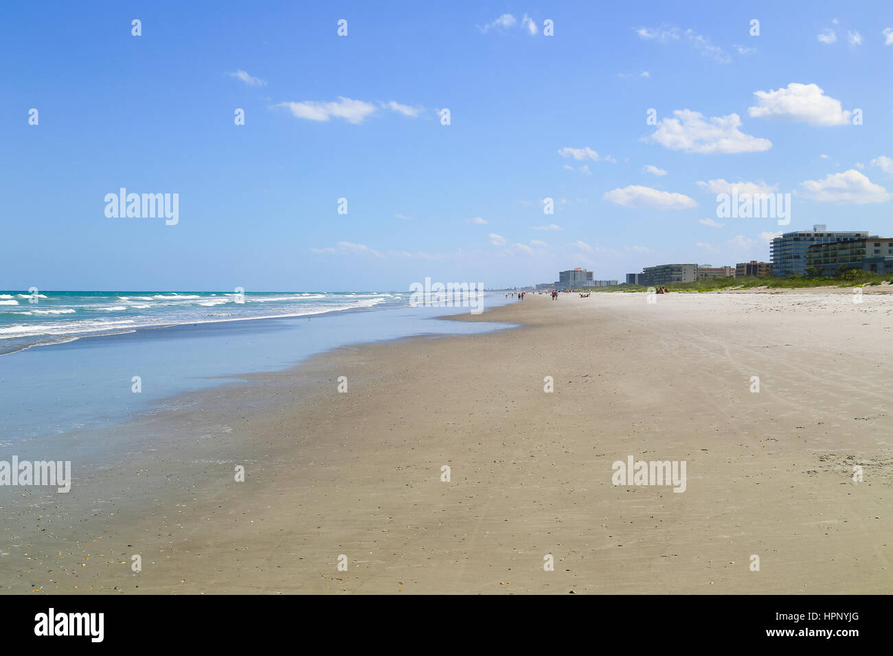 Looking down the beach in Cocoa Beach with only few people walking and ...