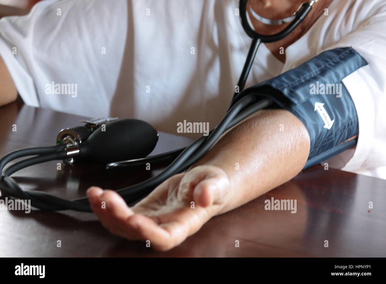 Woman is measuring the blood pressure using a manometer applied to her ...