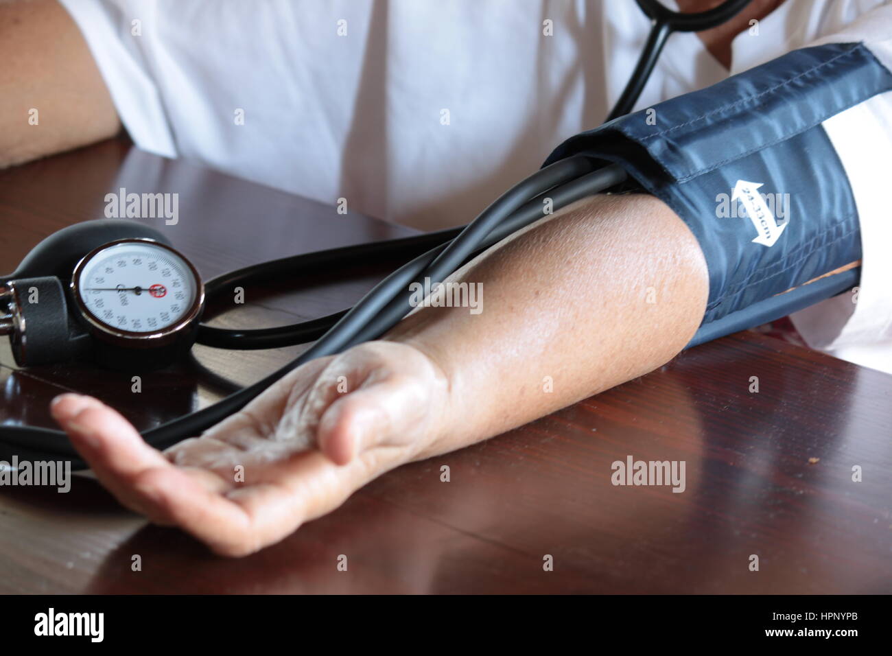 Woman is measuring the blood pressure using a manometer applied to her ...