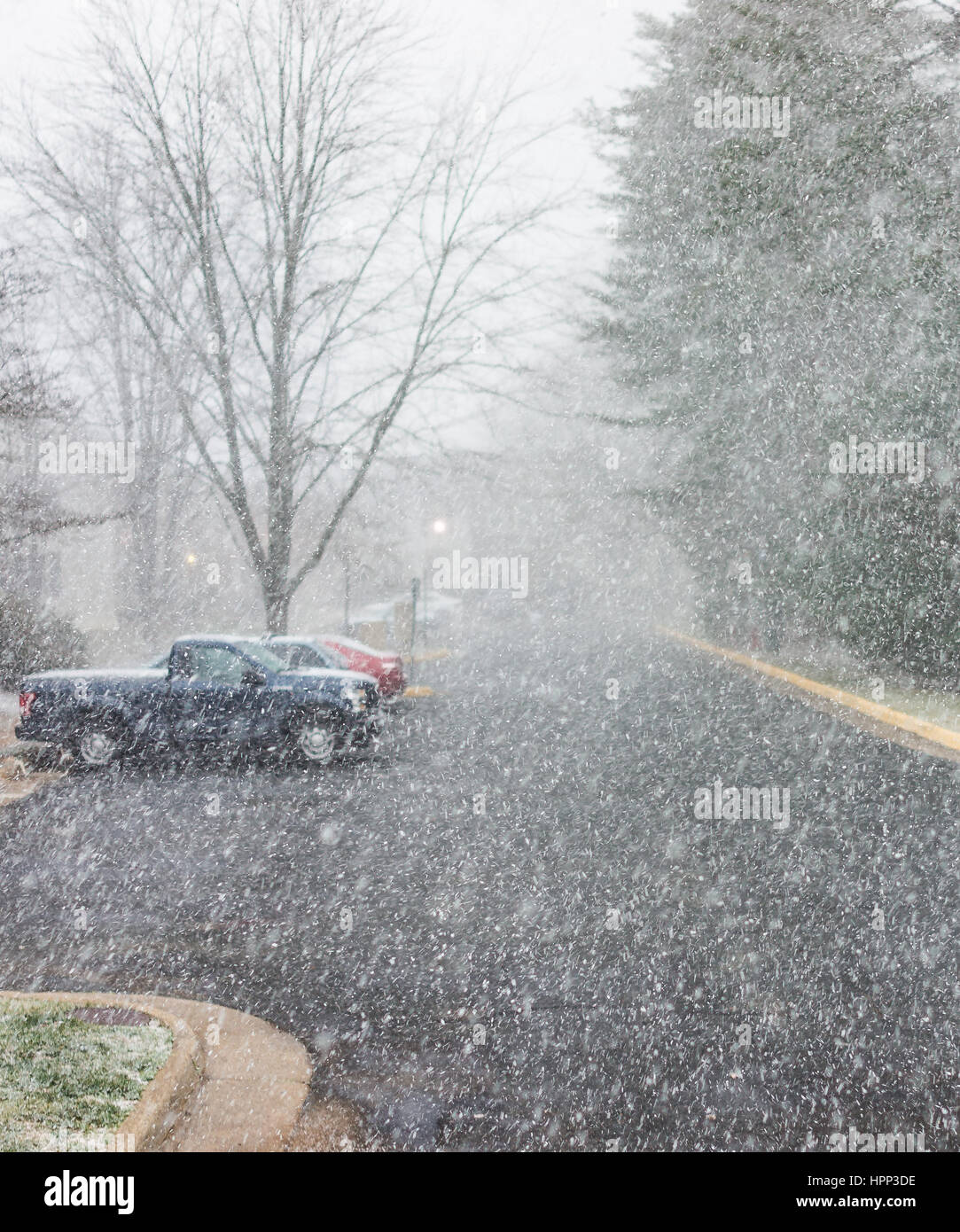 Heavy snowfall blizzard in neighborhood with road and houses Stock ...