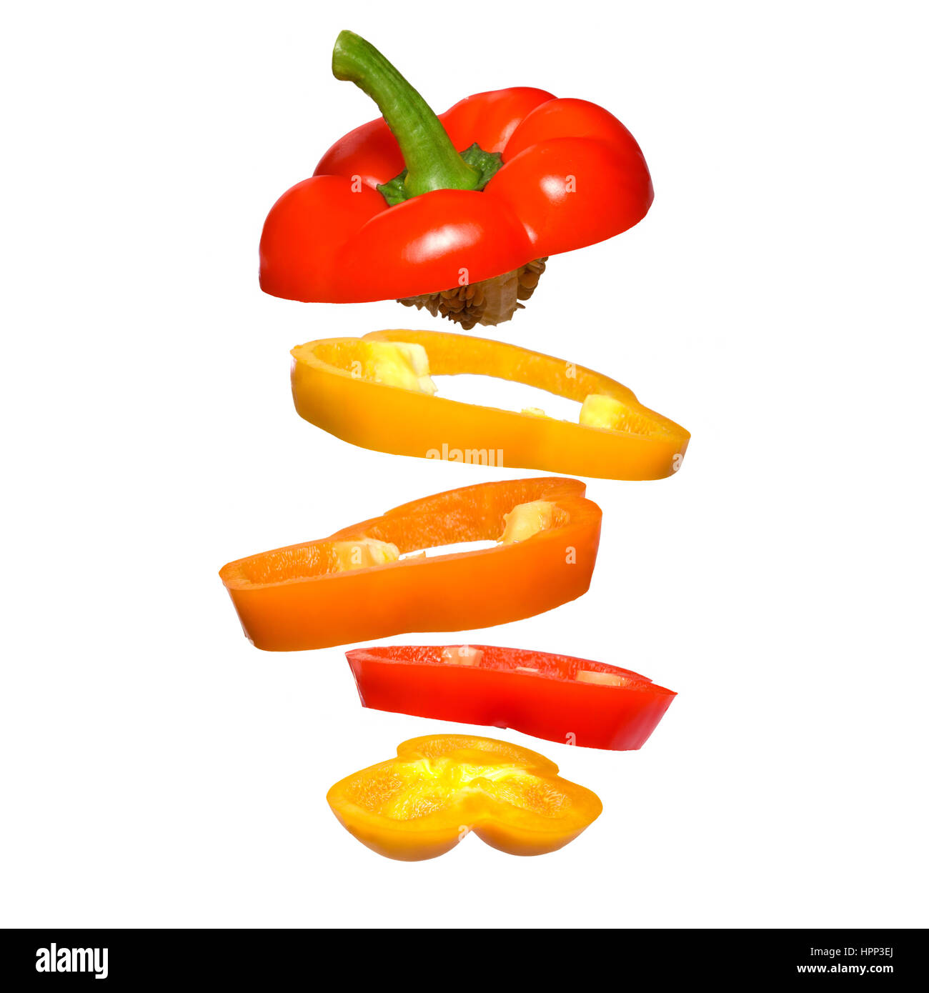 Flying red, orange and yellow paprika. Sliced floating pepper isolated ...