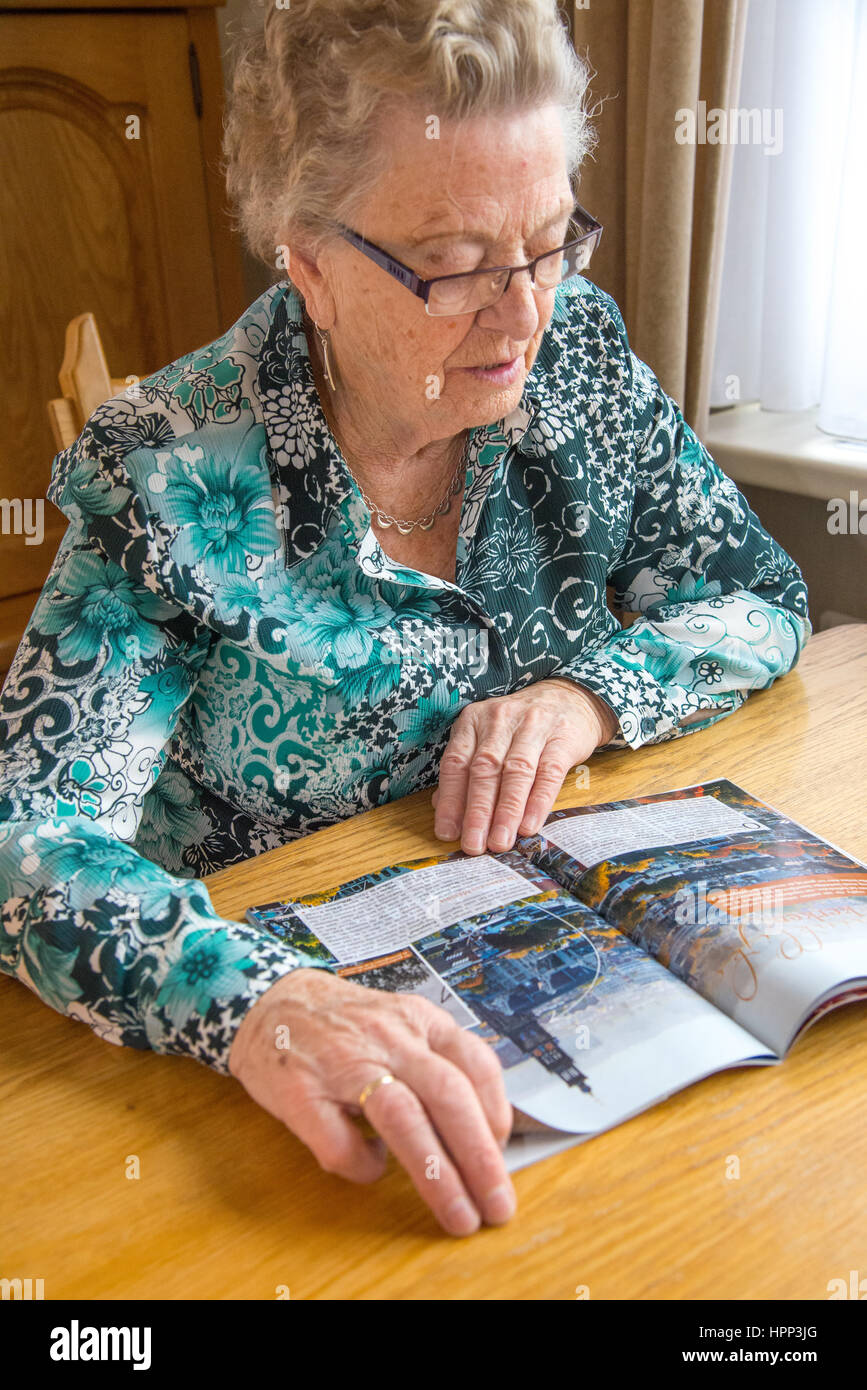 old caucasian woman reading at table Stock Photo - Alamy