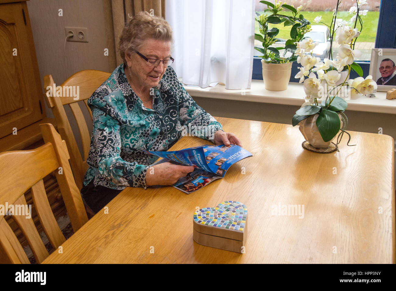 old caucasian woman reading at table Stock Photo - Alamy