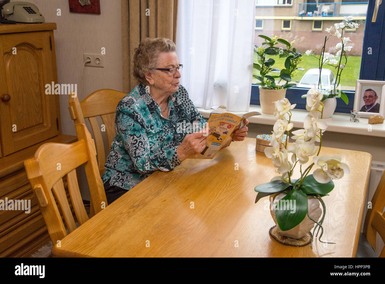 old caucasian woman reading at table Stock Photo - Alamy