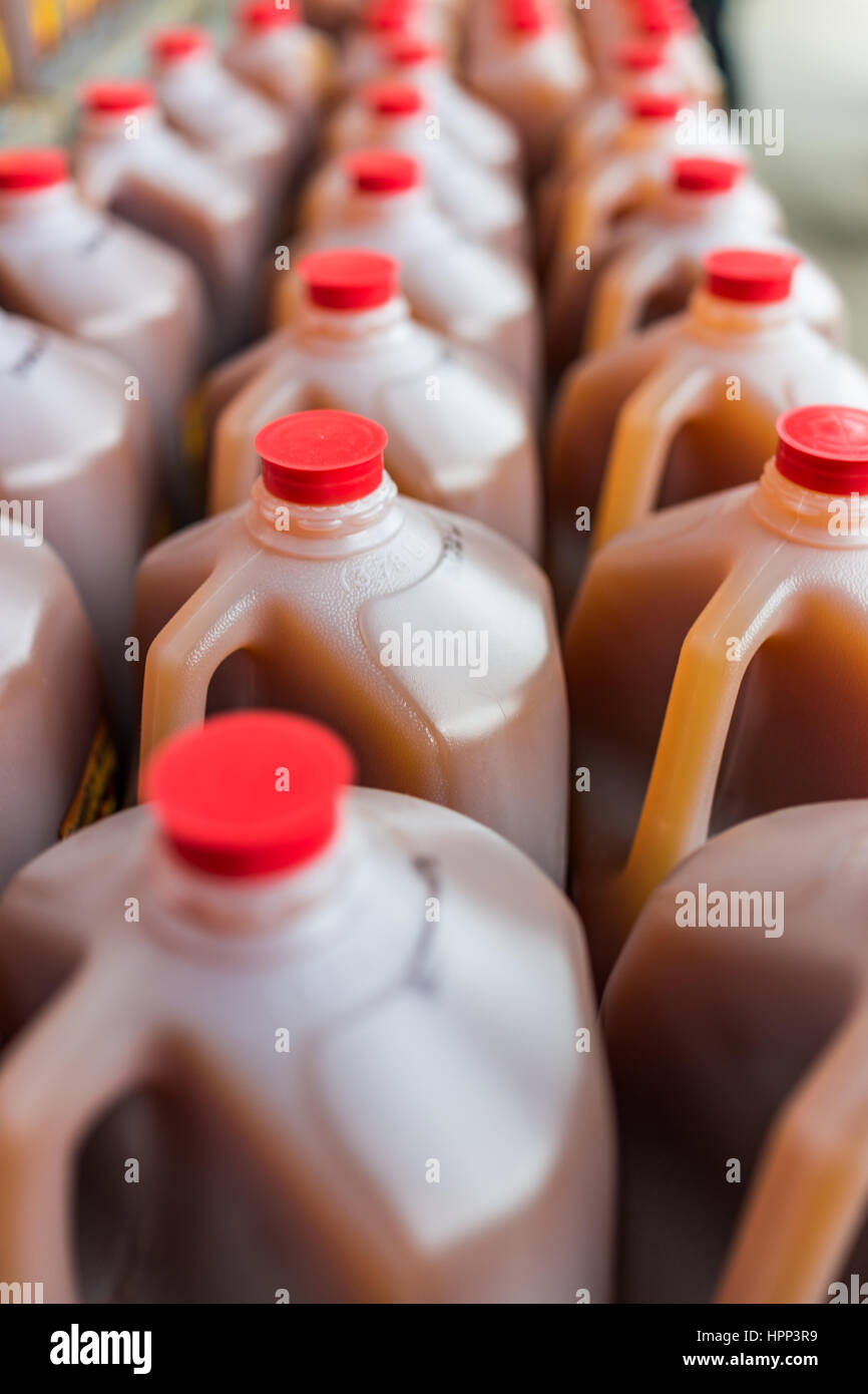 Rows of plastic gallon jars filled with apple cider Stock Photo - Alamy