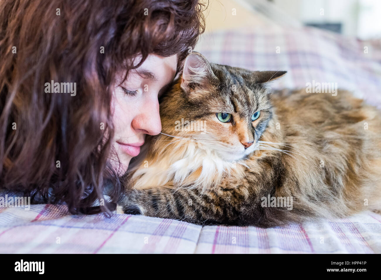 Young woman cuddling with unhappy maine coon cat Stock Photo - Alamy