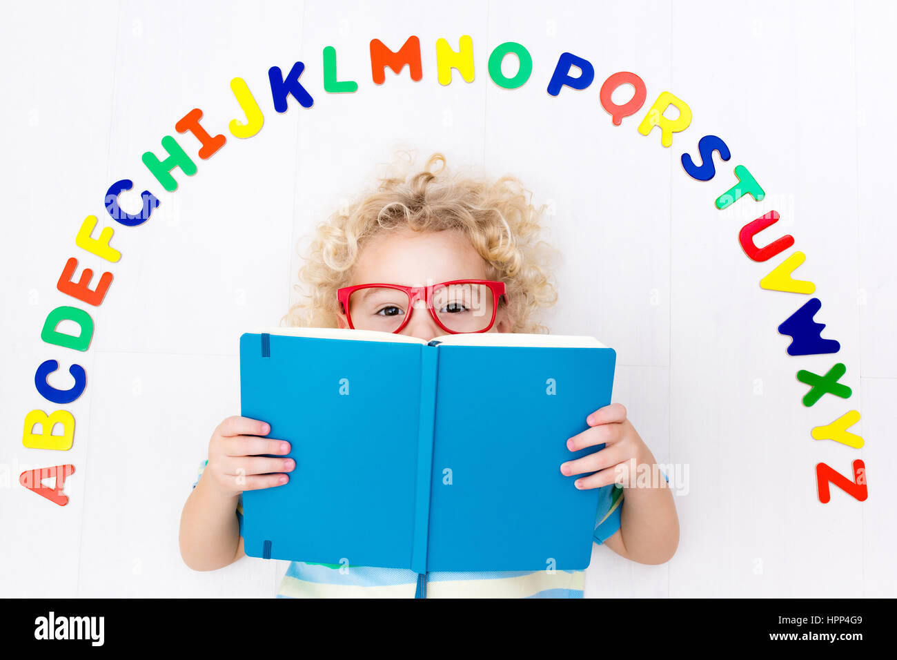 Happy preschool child learning to read and write playing with colorful ...
