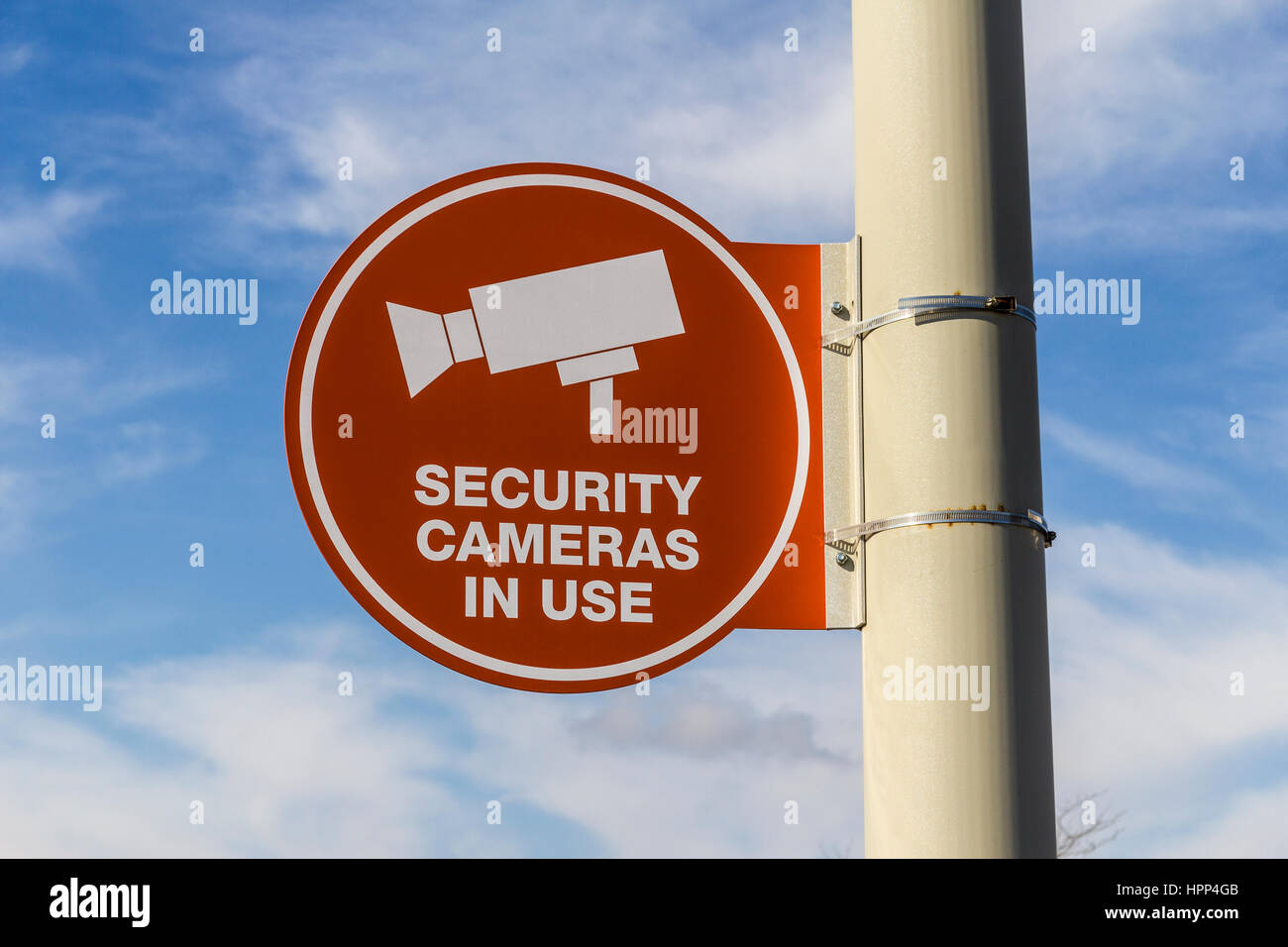 Orange Security Camera In Use Sign on Gray Post and Partly Sunny ...