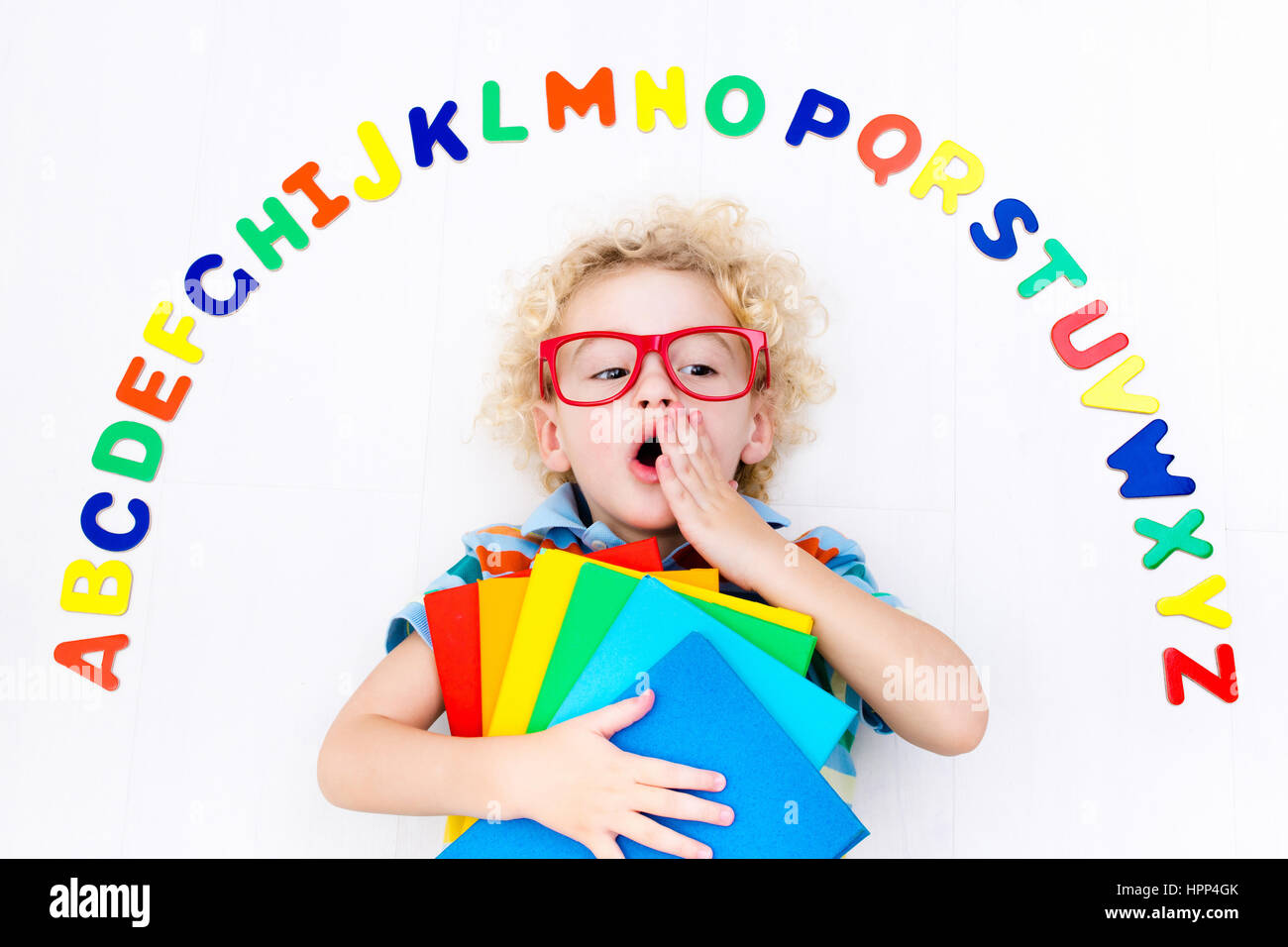 Happy preschool child learning to read and write playing with colorful ...