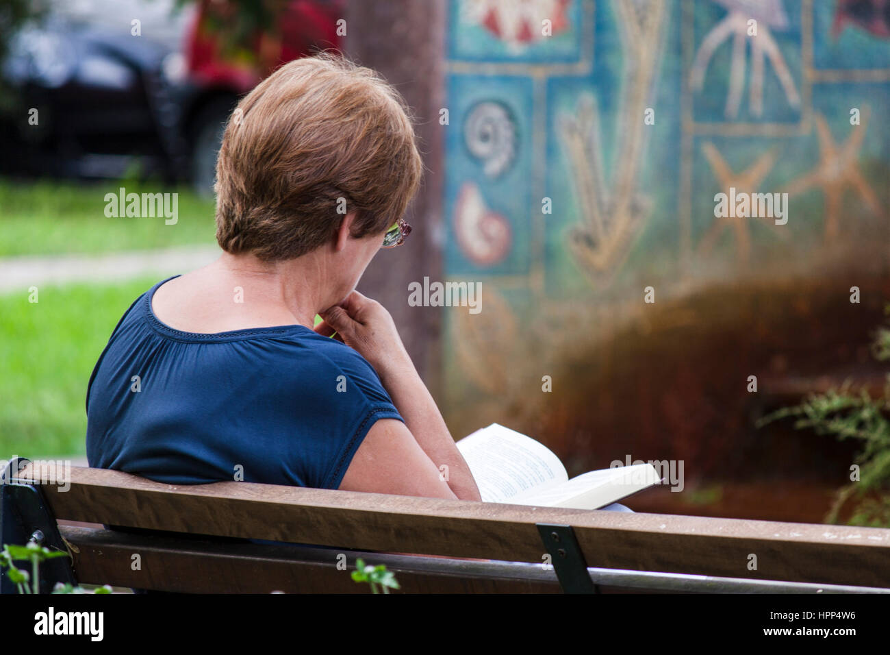 Woman park bench alone reading hi-res stock photography and images - Alamy