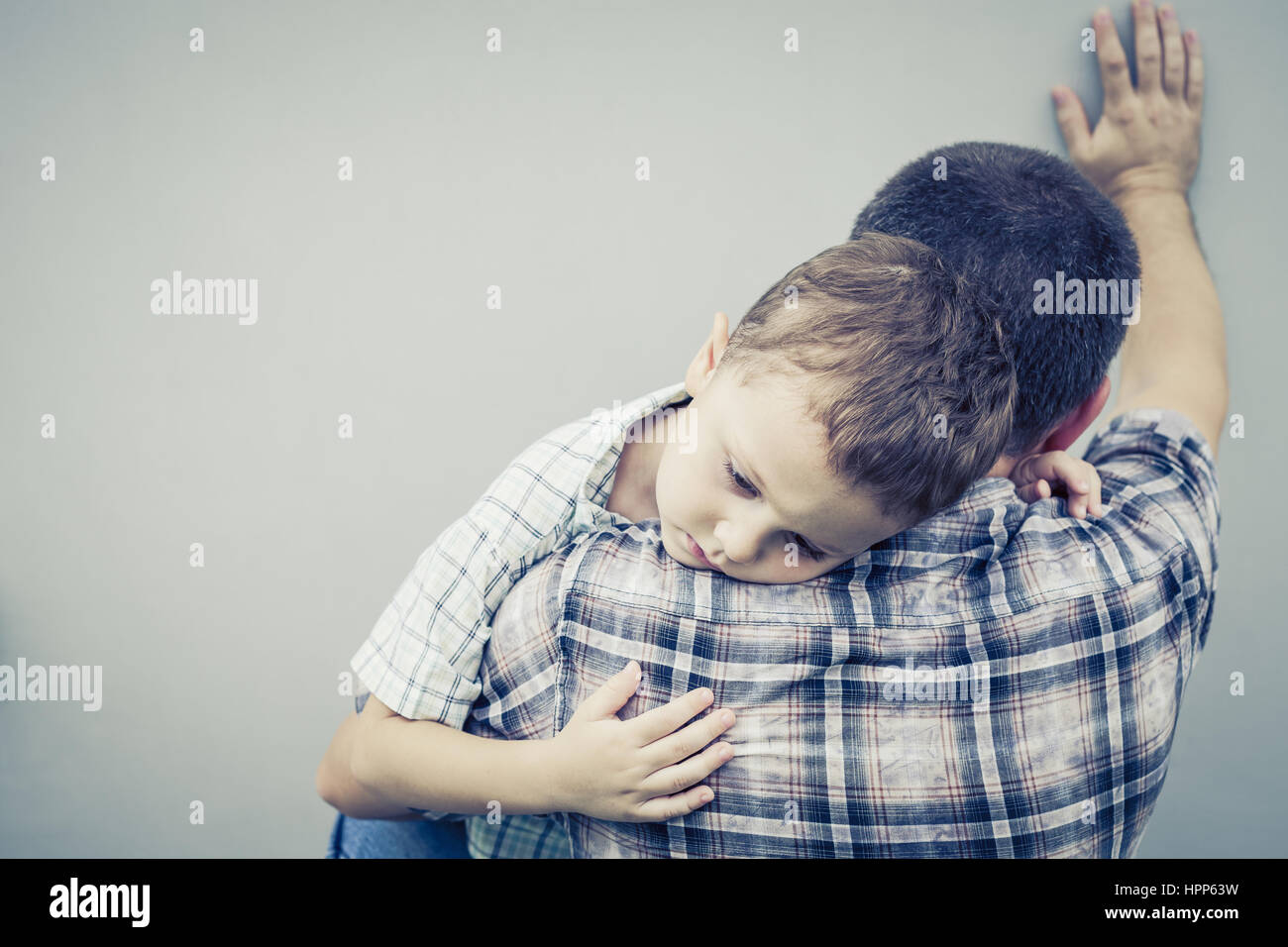 sad son hugging his dad near wall at the day time Stock Photo - Alamy