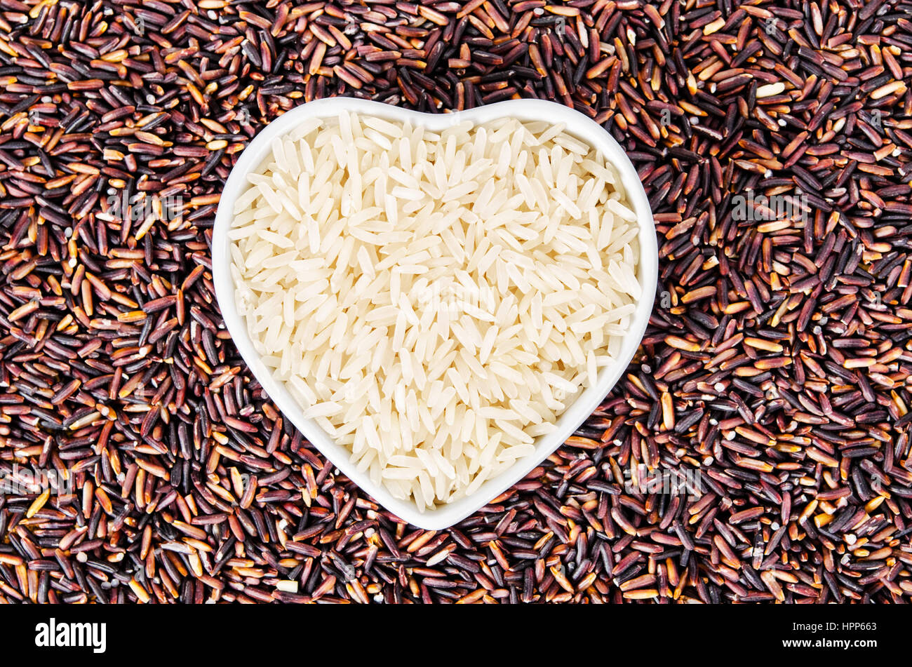 Raw white rice in heart shape bowl on rice berry background Stock Photo ...