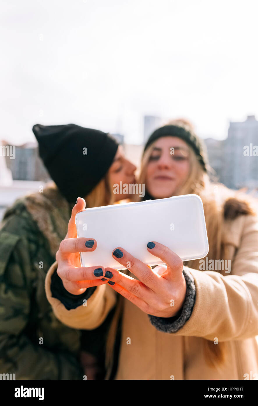 Two friends taking selfie with smartphone Stock Photo - Alamy