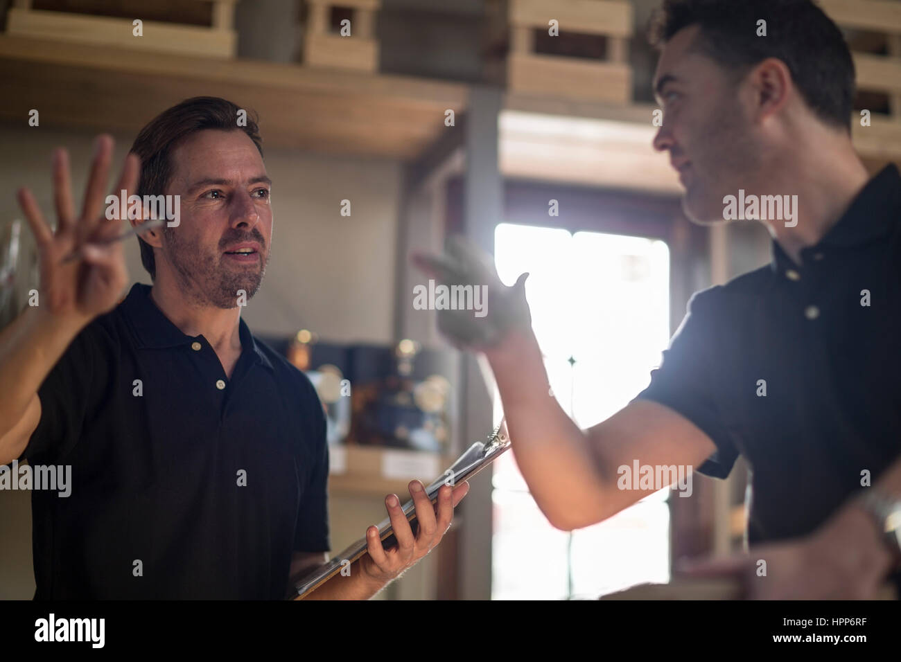 Two men discussing in warehouse Stock Photo - Alamy