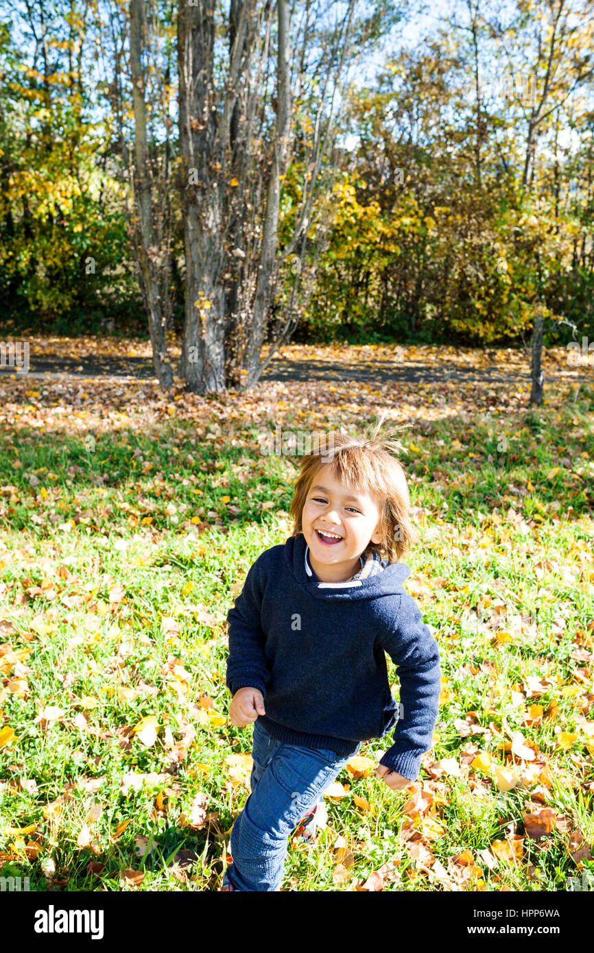 Happy little boy running on a meadow Stock Photo - Alamy