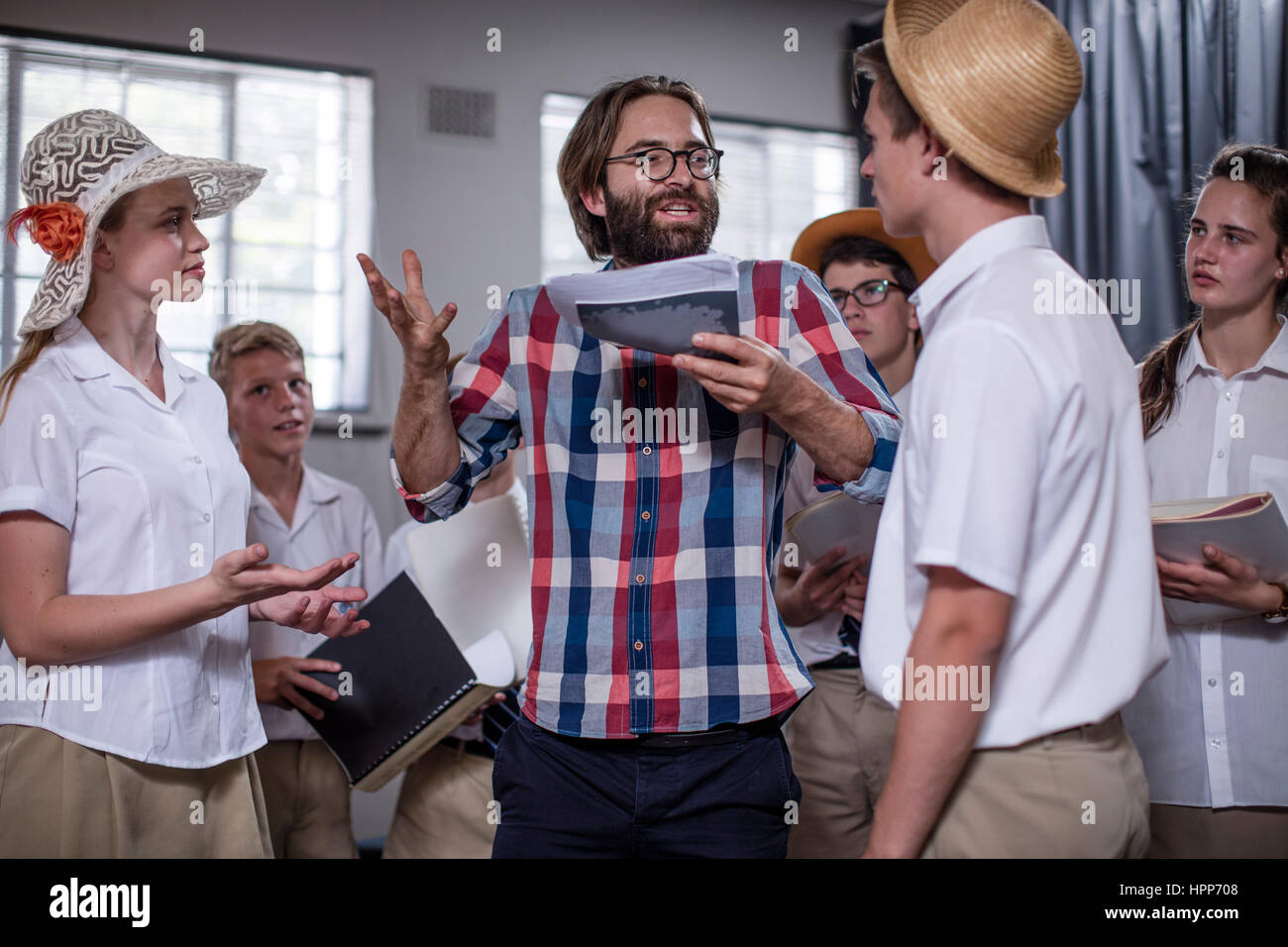 Drama teacher eading students wearing props Stock Photo - Alamy