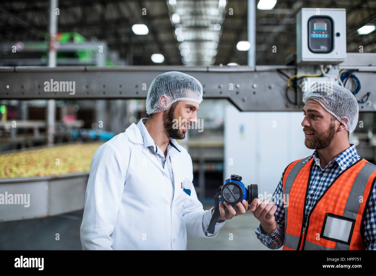 Two men talking in food processing plant Stock Photo - Alamy