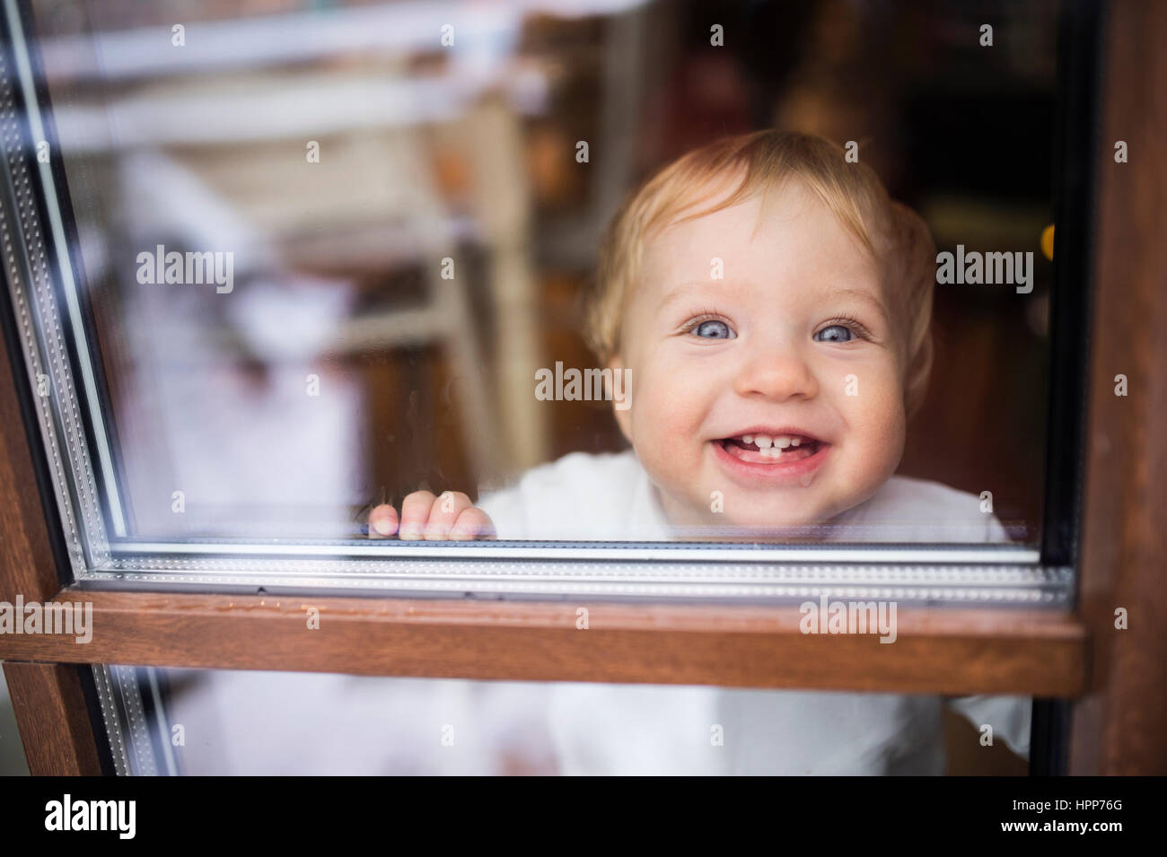 Laughing baby boy looking out of window Stock Photo - Alamy