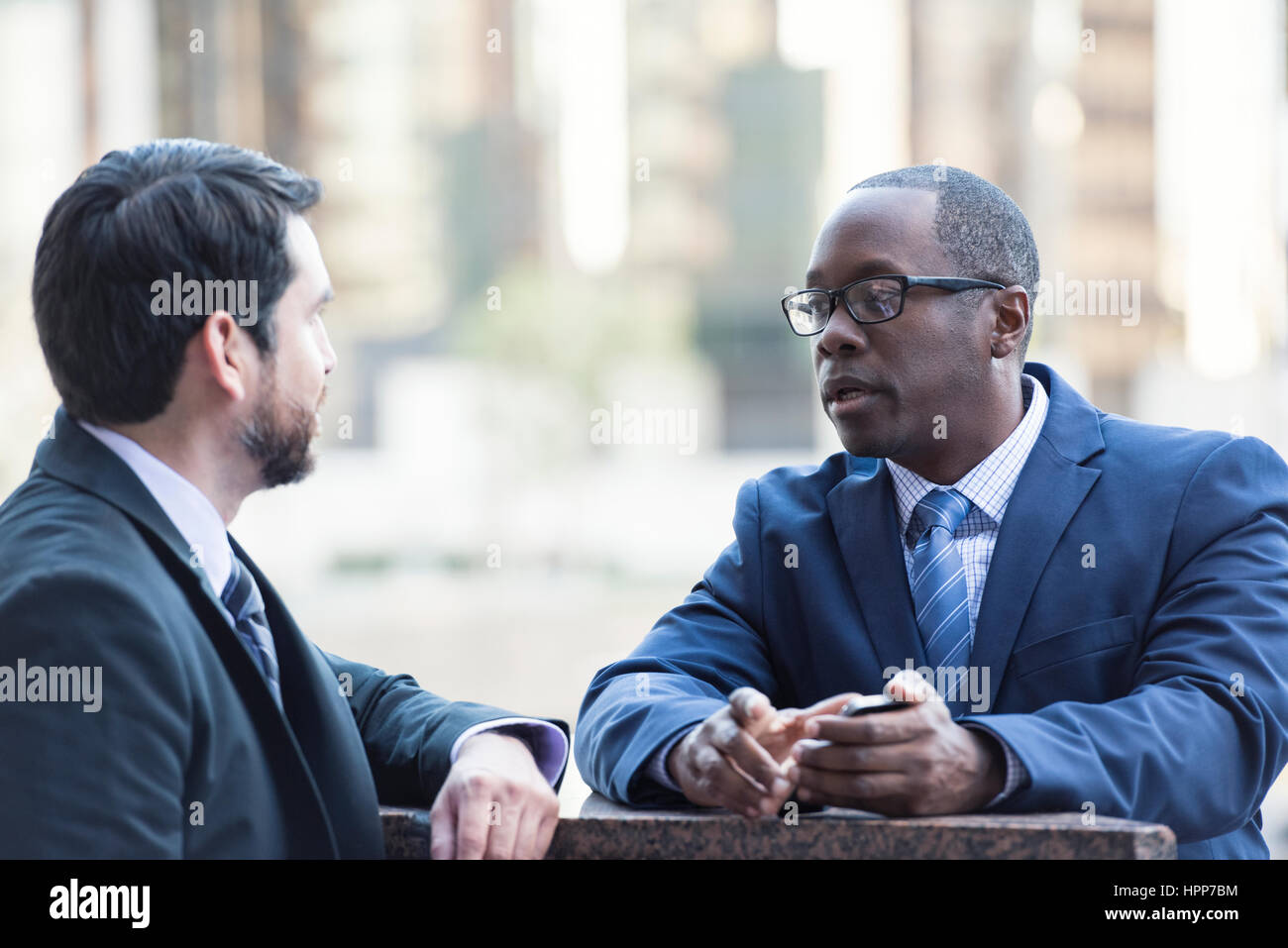 Two businessmen talking outdoors Stock Photo - Alamy