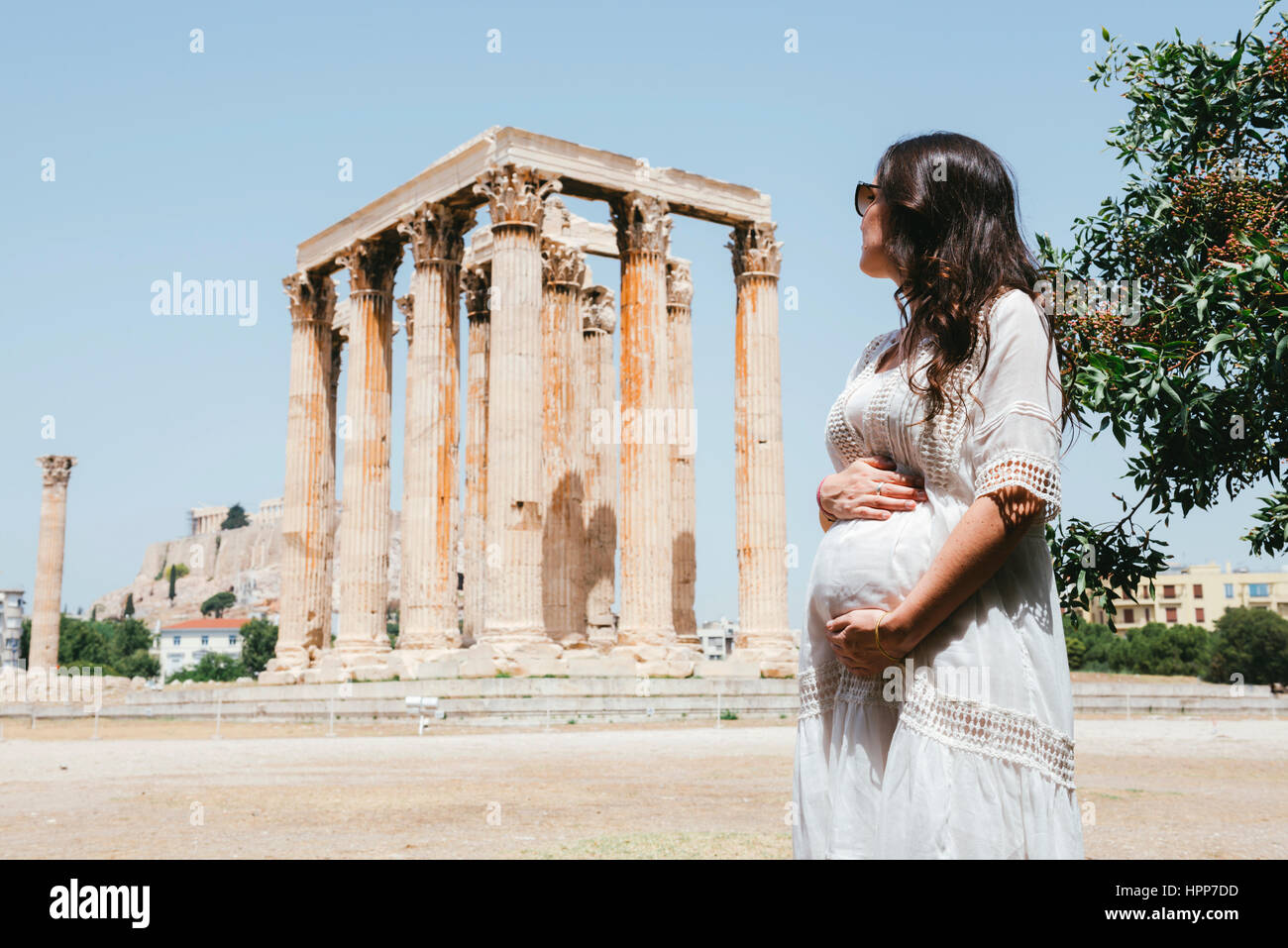 Greece, Athens, pregnant woman visiting the Olympieion with the ...