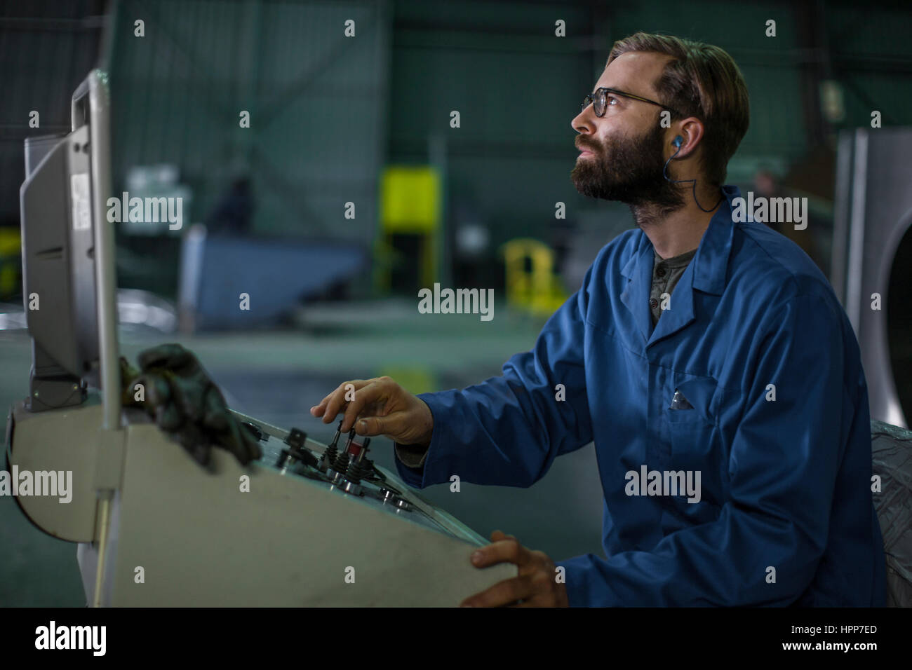 Worker operating machinery at control panel in factory Stock Photo - Alamy