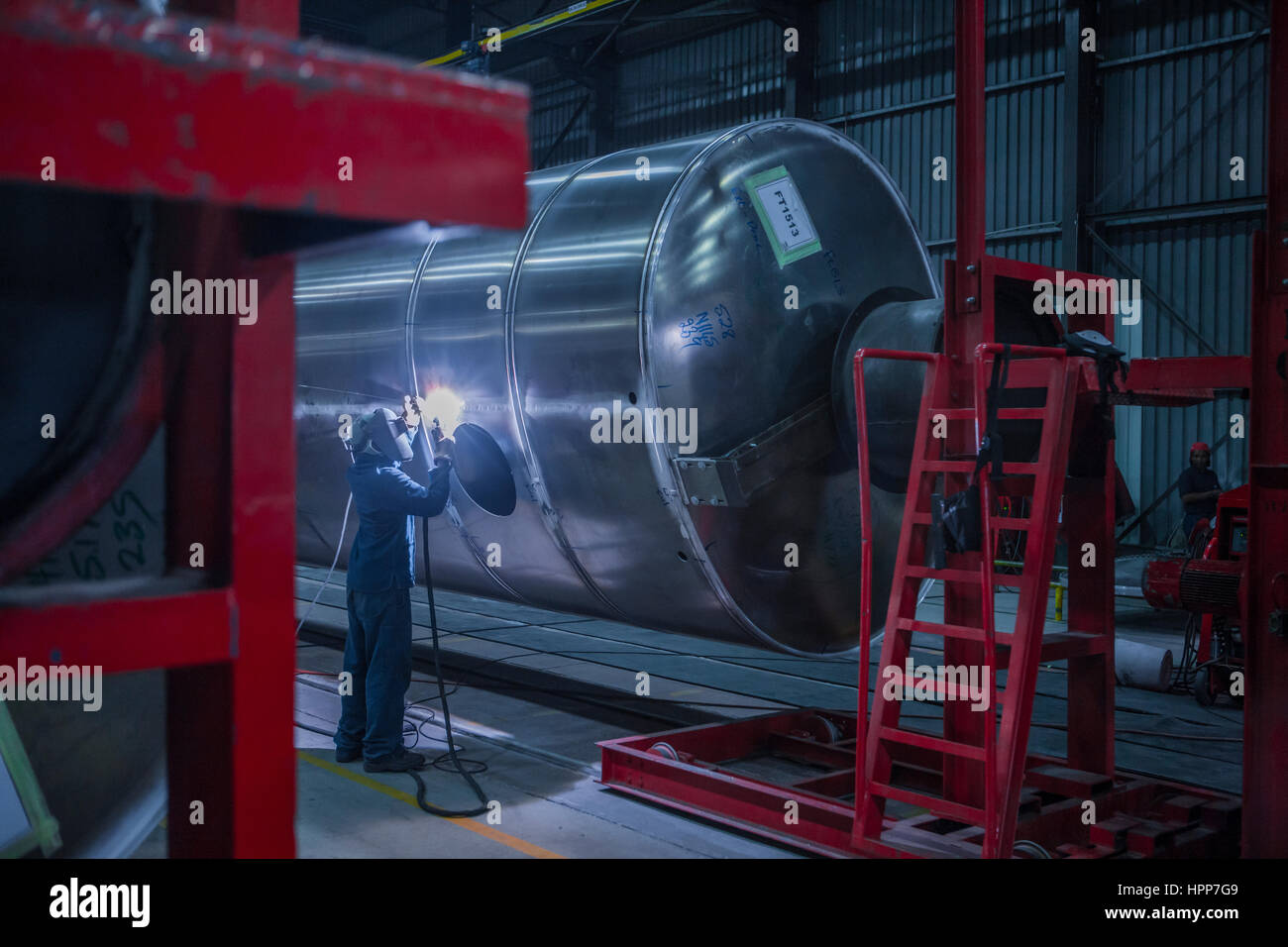 Man welding large steel tank in factory Stock Photo - Alamy