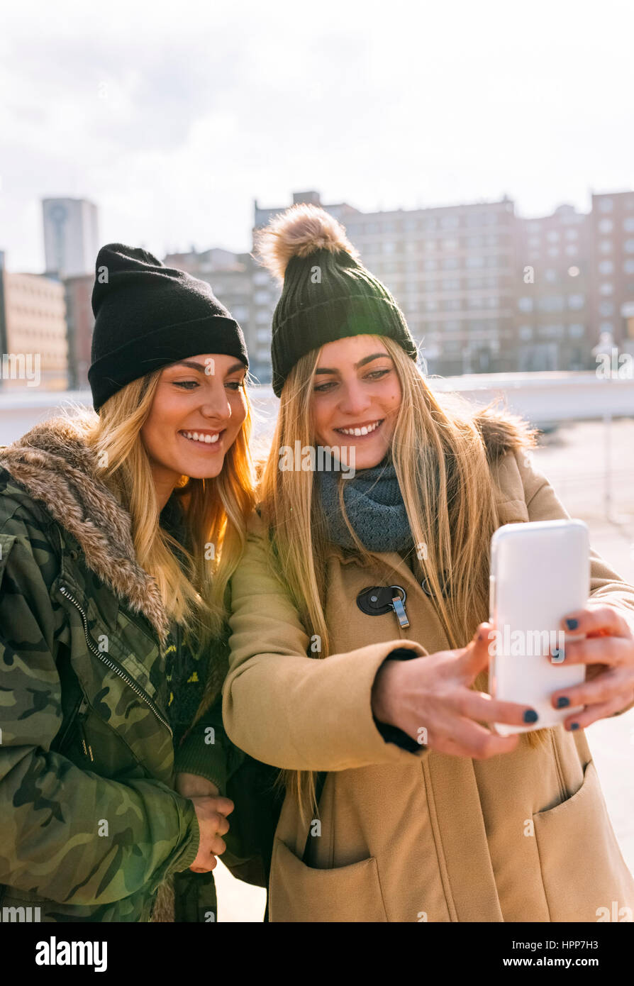 Two friends taking selfie with smartphone Stock Photo - Alamy