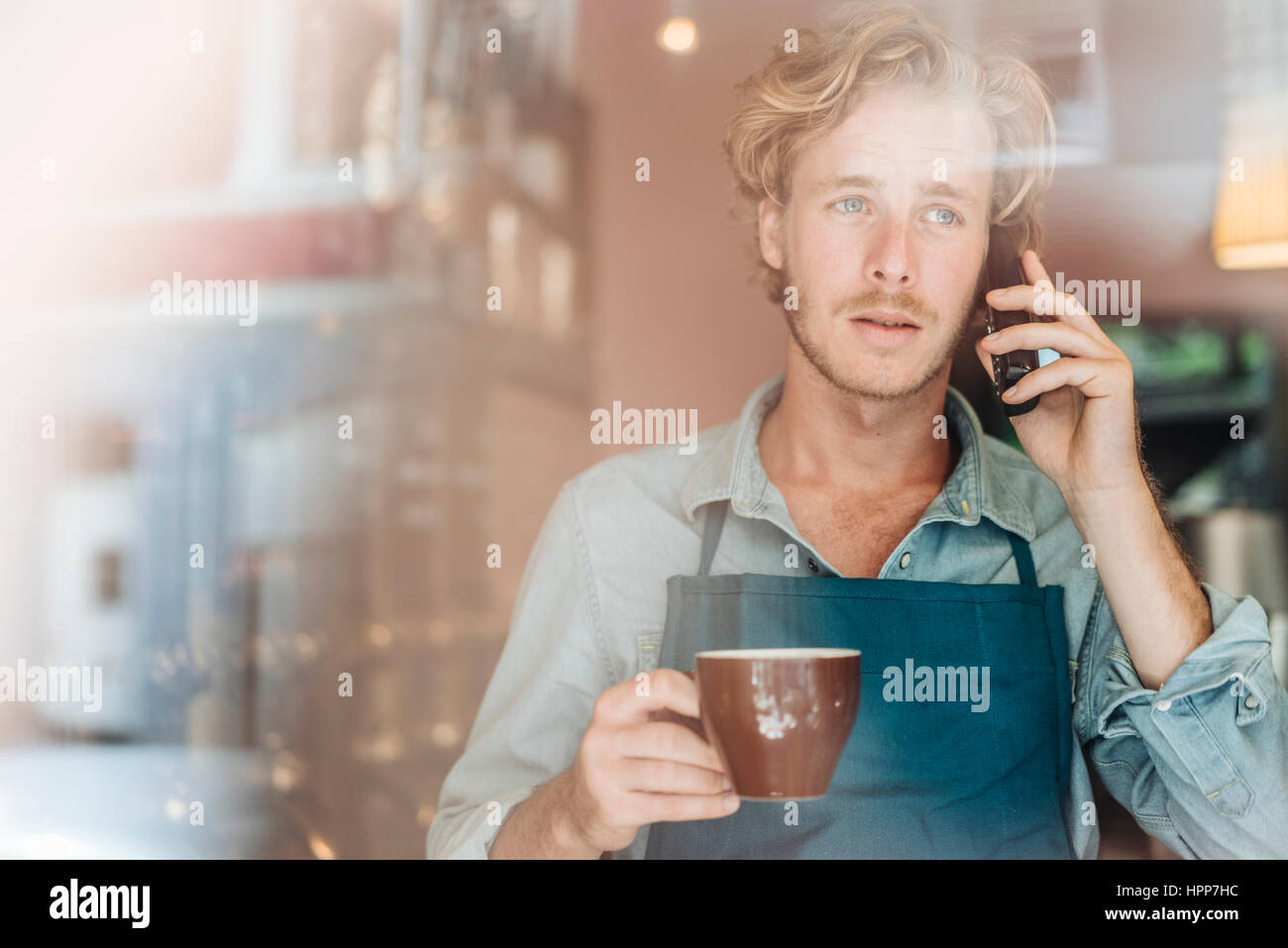 Coffee roaster in his shop on the phone Stock Photo - Alamy