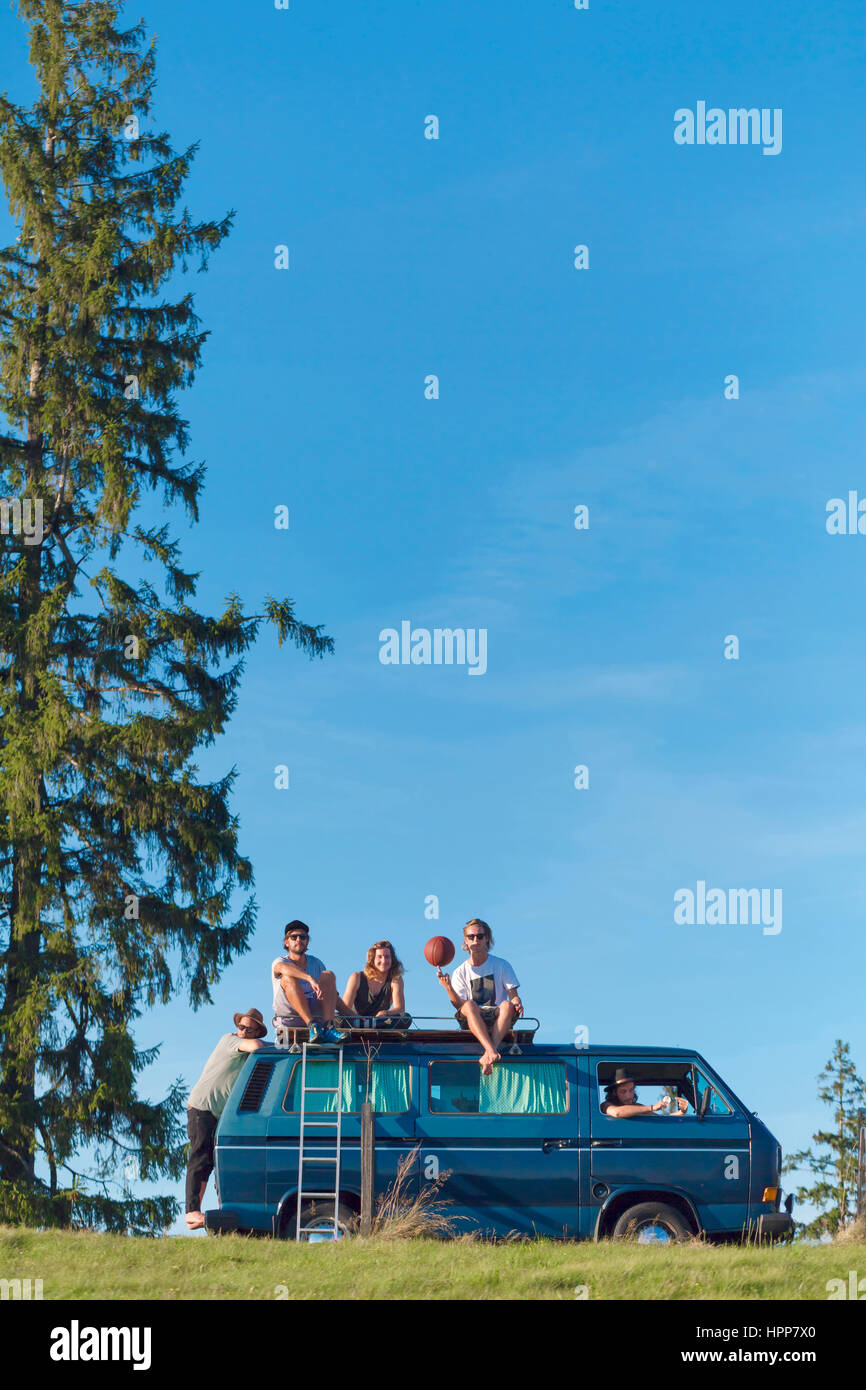 Group of friends sitting on van in the nature Stock Photo - Alamy