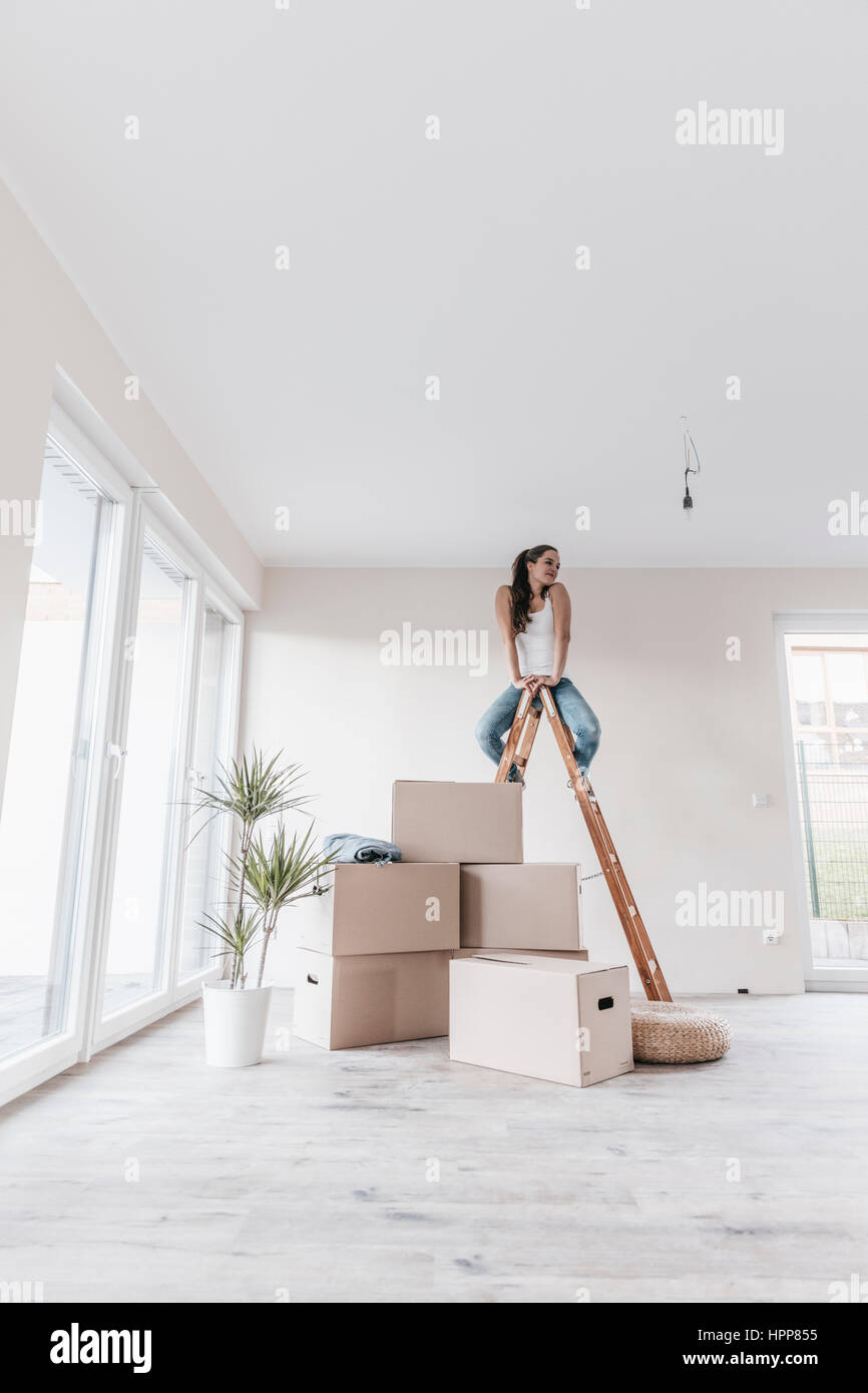 Mature woman sitting on ladder in her new home Stock Photo - Alamy