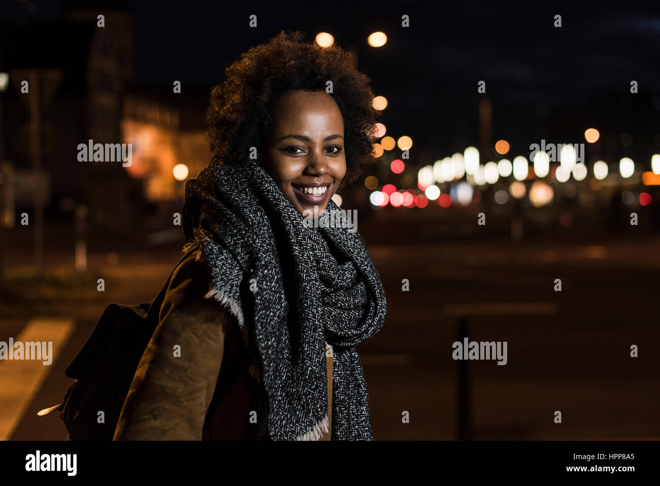 Portrait of smiling young woman at roadside by night Stock Photo - Alamy
