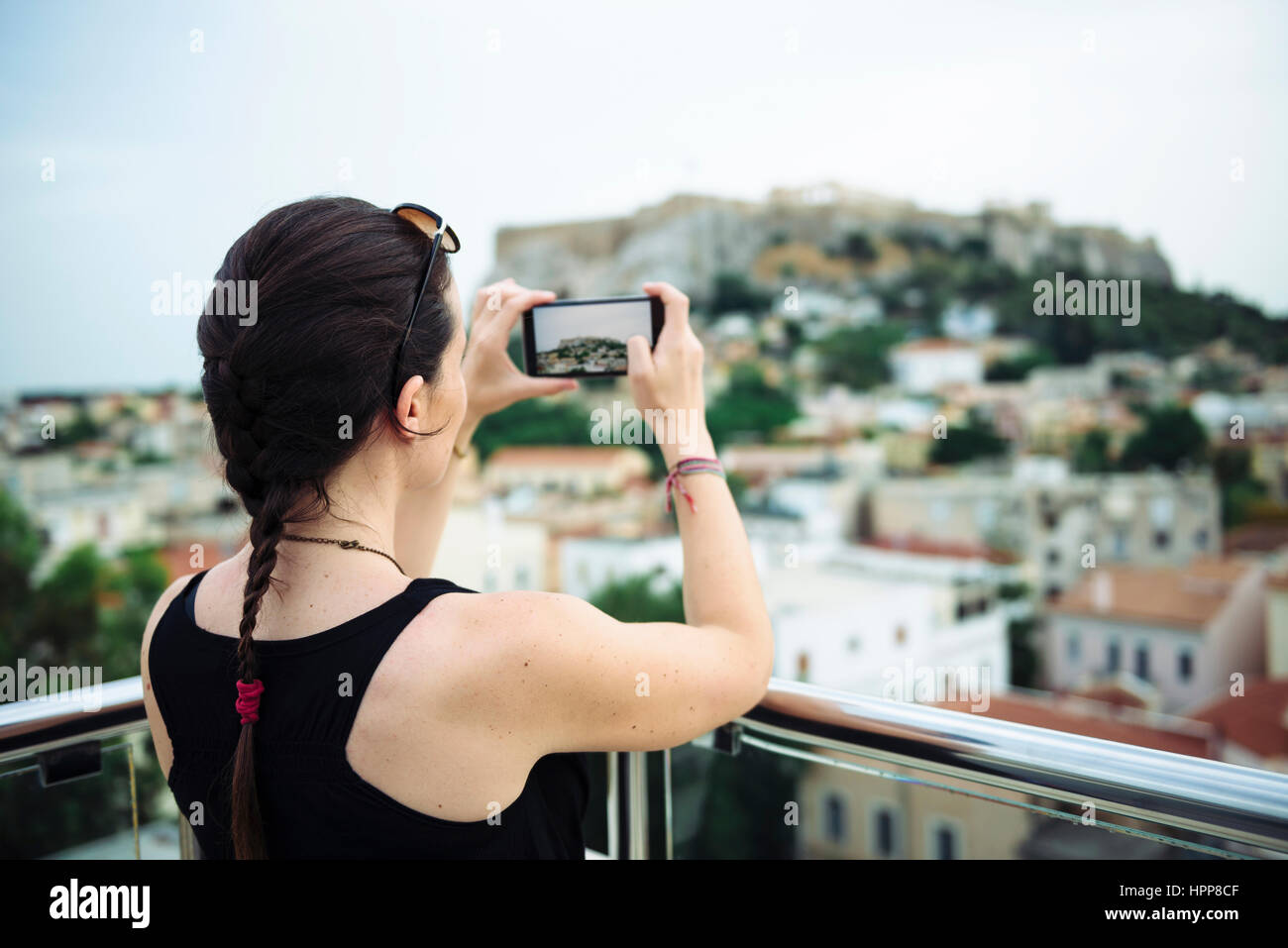 Greece, Athens, woman taking a cell phone picture of the Parthenon temple in the Acropolis ...