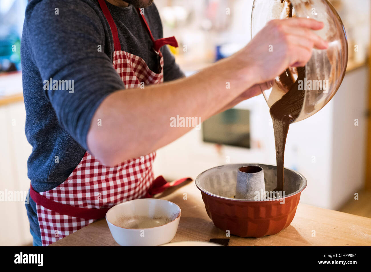 Man standing in kitchen baking chocolate cake Stock Photo - Alamy